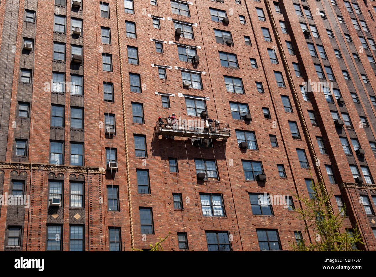 Men on a window cleaning platform hanging off the side of the London ...