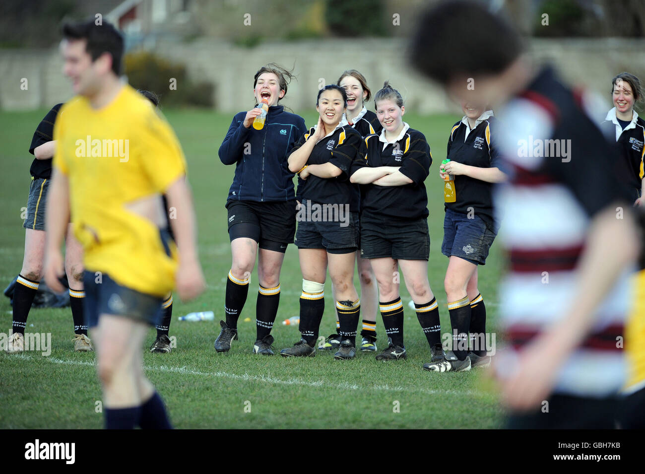 Participants on the touchline are all smiles as they stop to watch ...