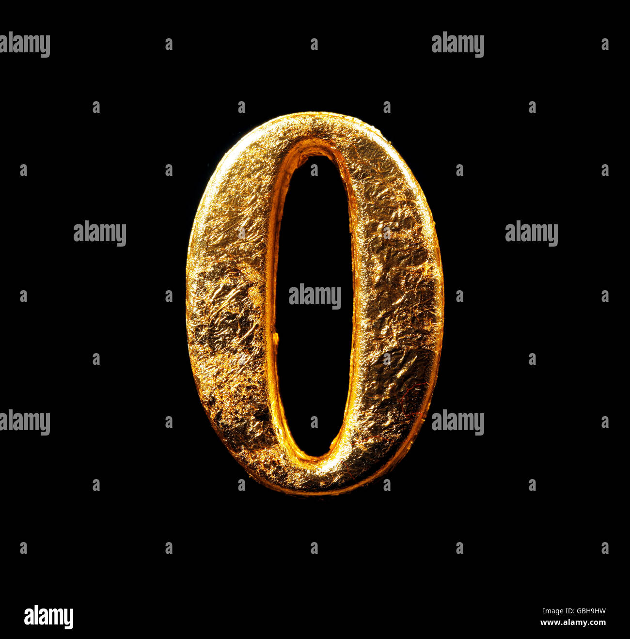 Alphabet and numbers in gold leaf isolated on black Stock Photo - Alamy