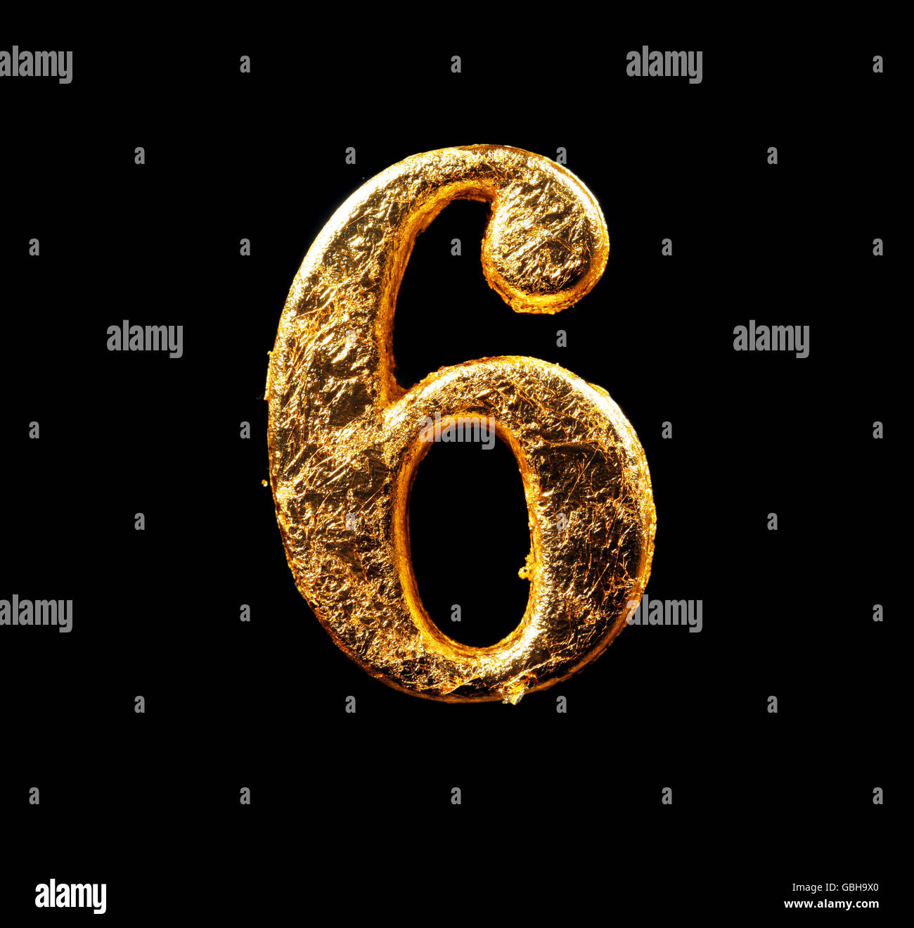Alphabet and numbers in gold leaf isolated on black Stock Photo - Alamy