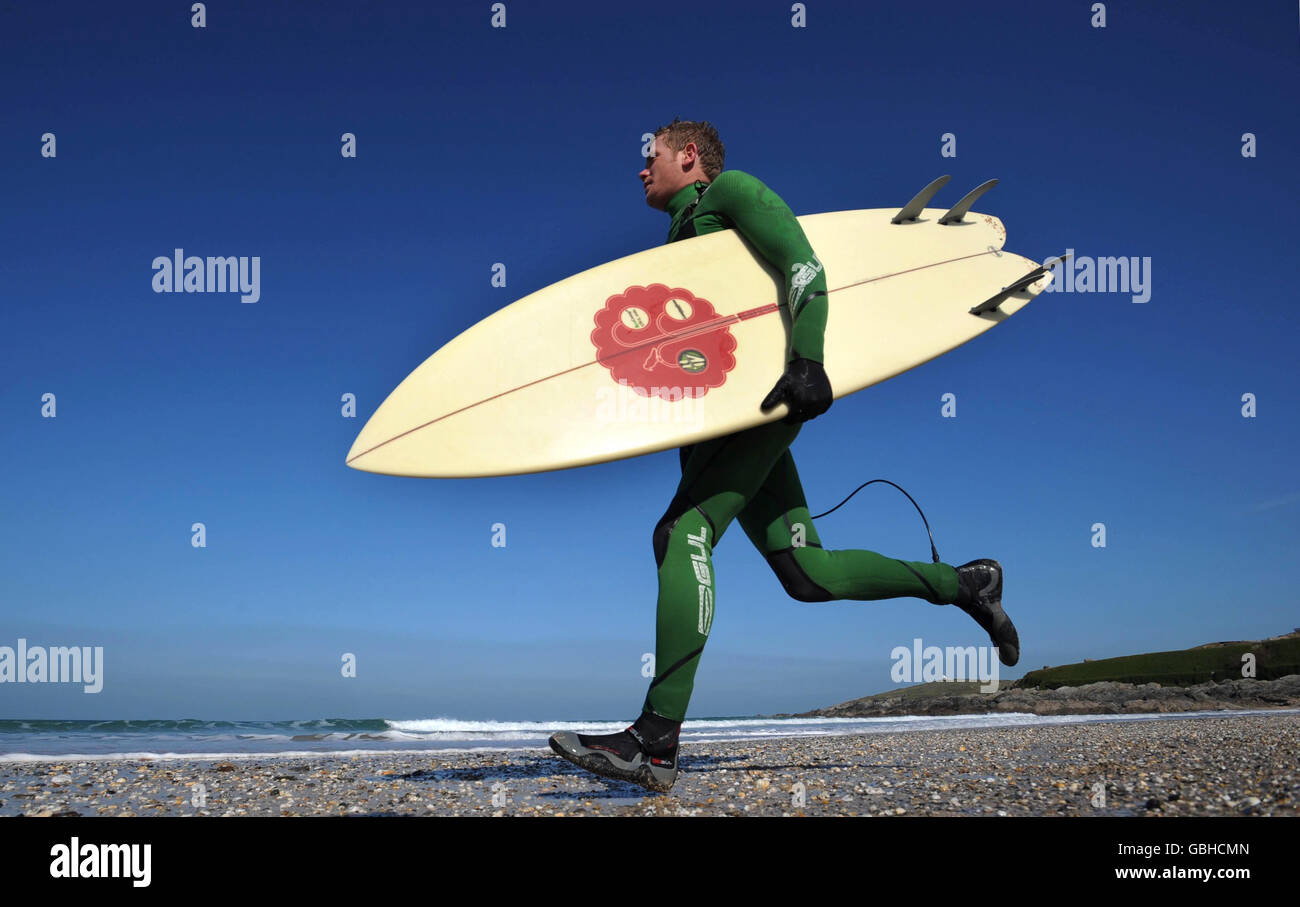 Holds an environmentally friendly surfboard off fistral beach hi-res ...