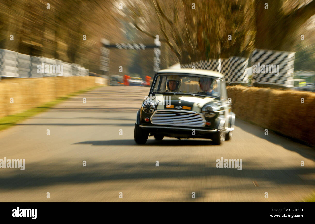 A 1960's Mini Cooper S races up the hill course at Goodwood House near ...