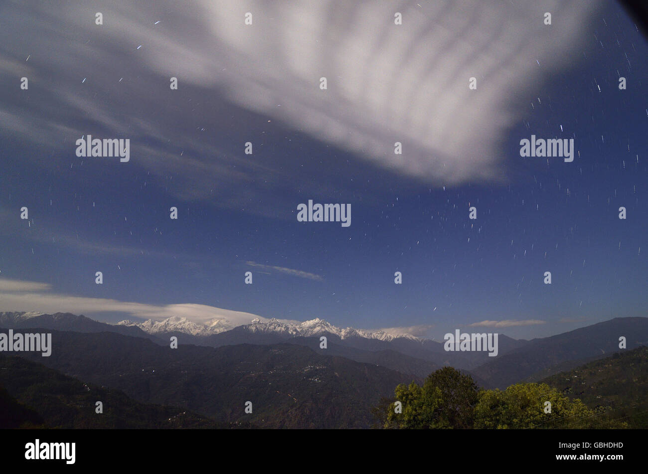 Kanchanjunga range glowing in moonlight along with star trails, Sikkim ...