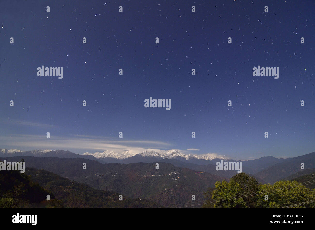 Kanchanjunga range glowing in moonlight along with star trails, Sikkim ...