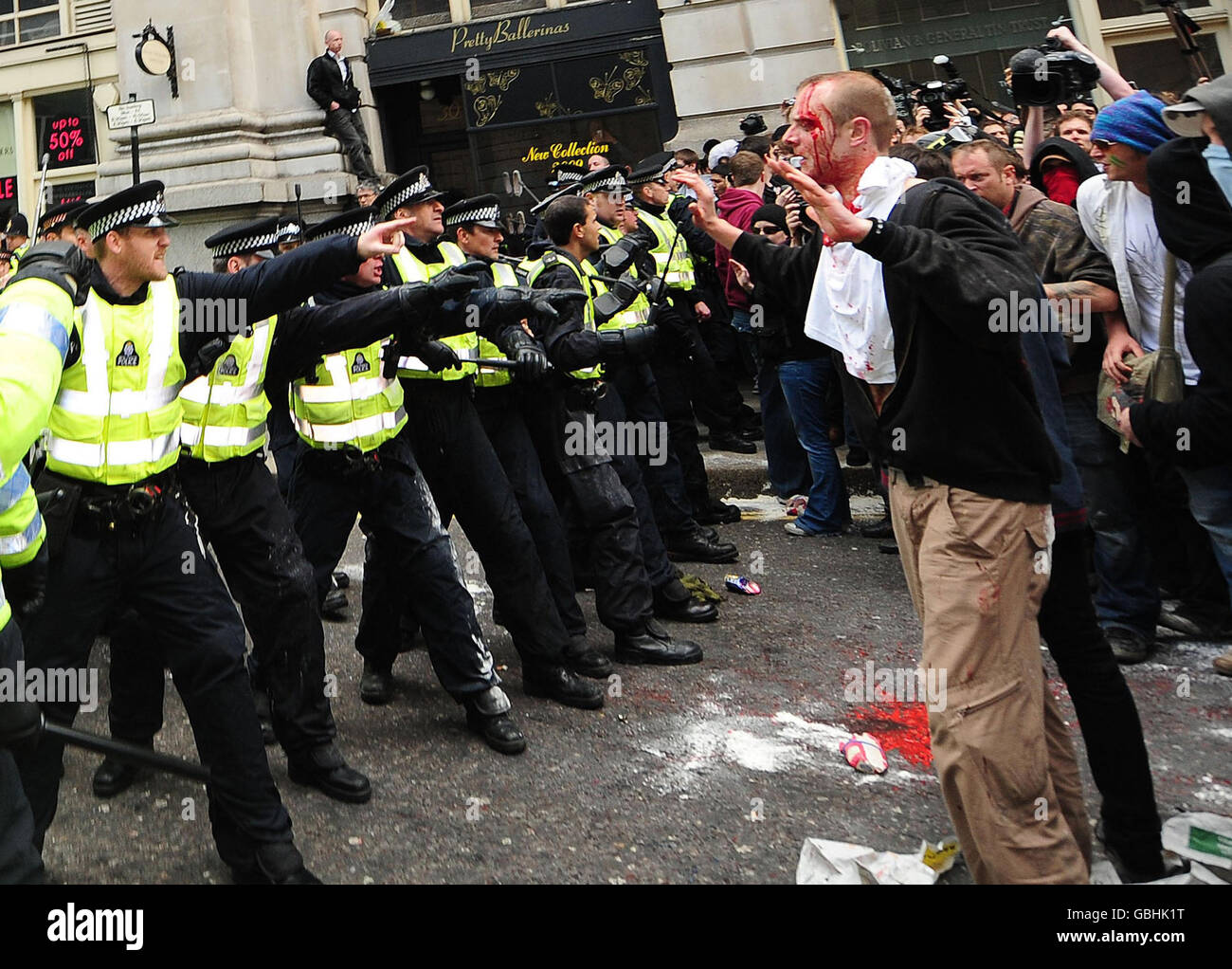 An injured man confronts police as they attempt to subdue the crowds ...