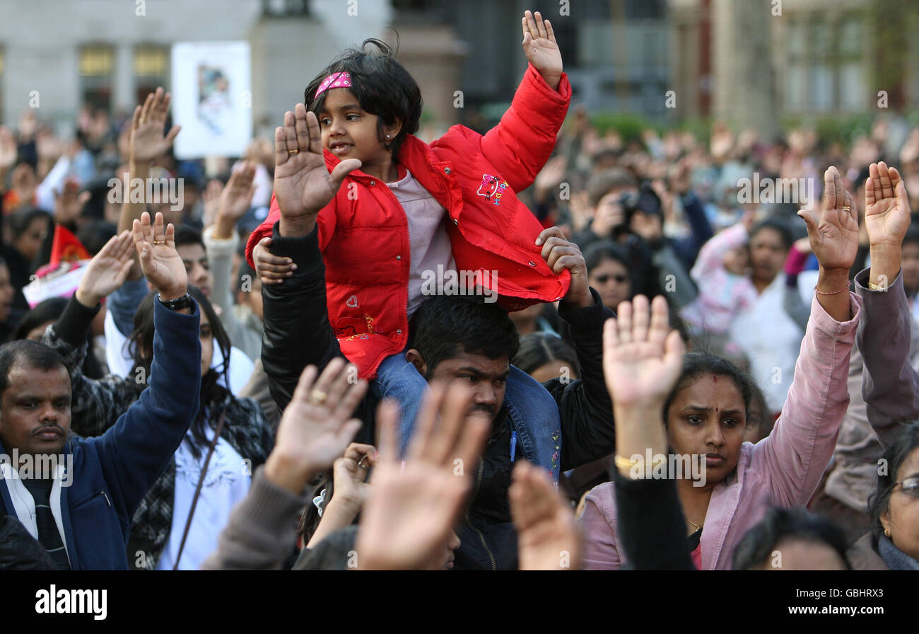 Demonstrators raise their hands during a minutes silence as they take ...