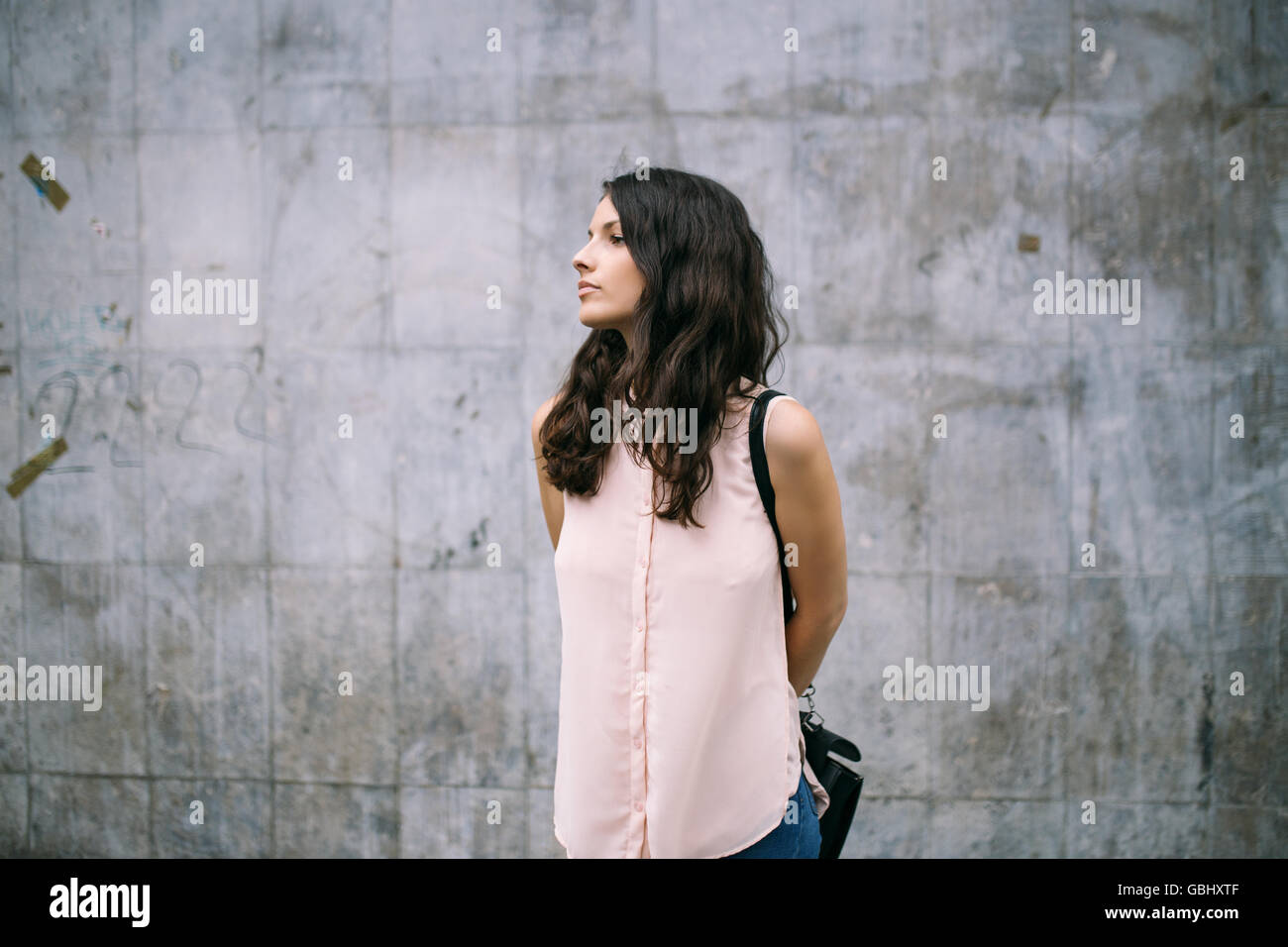 Portrait of a young woman in front of a wall Stock Photo - Alamy