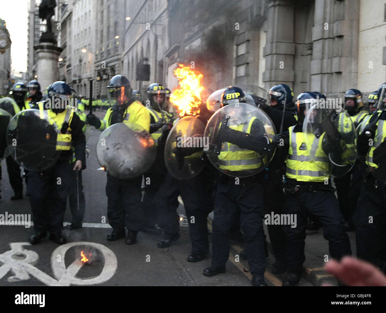 A police officer is hit by a burning object thrown during ...