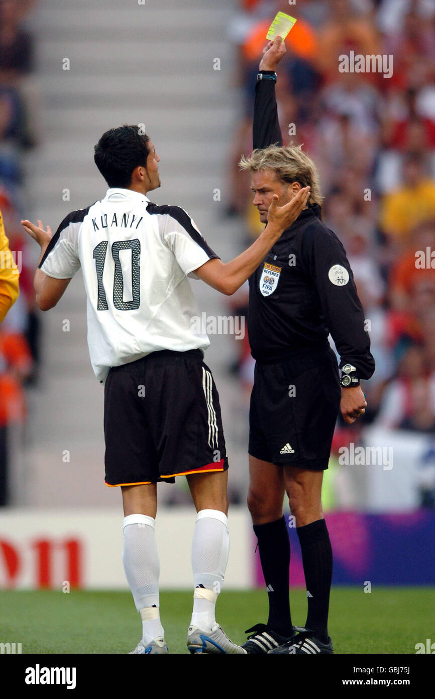 Germany's Kevin Kuranyi is shown a yellow card by referee Anders Frisk ...