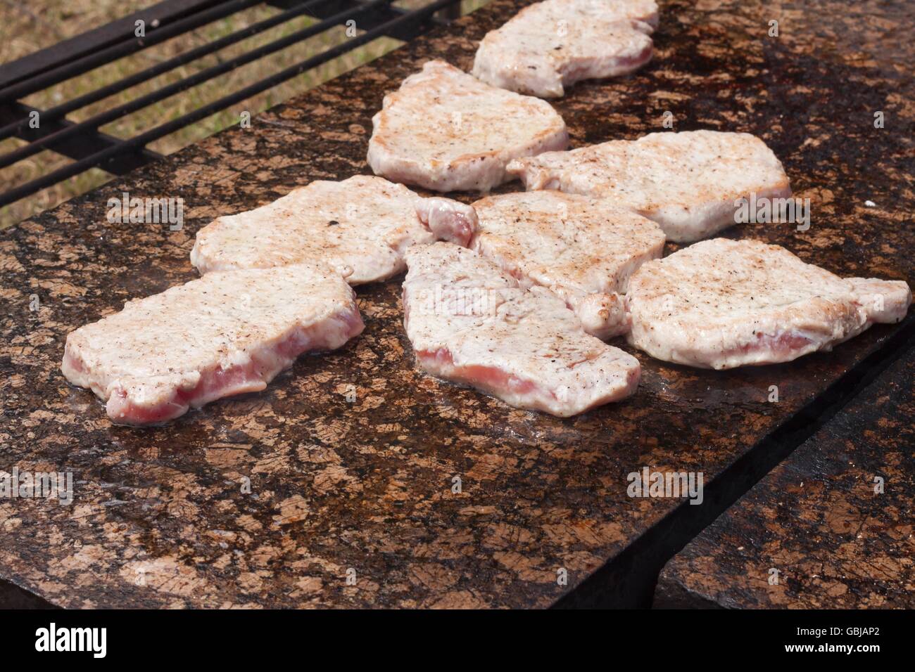 Barbecue pork chops and chicken on a hot granite countertop. Summer ...