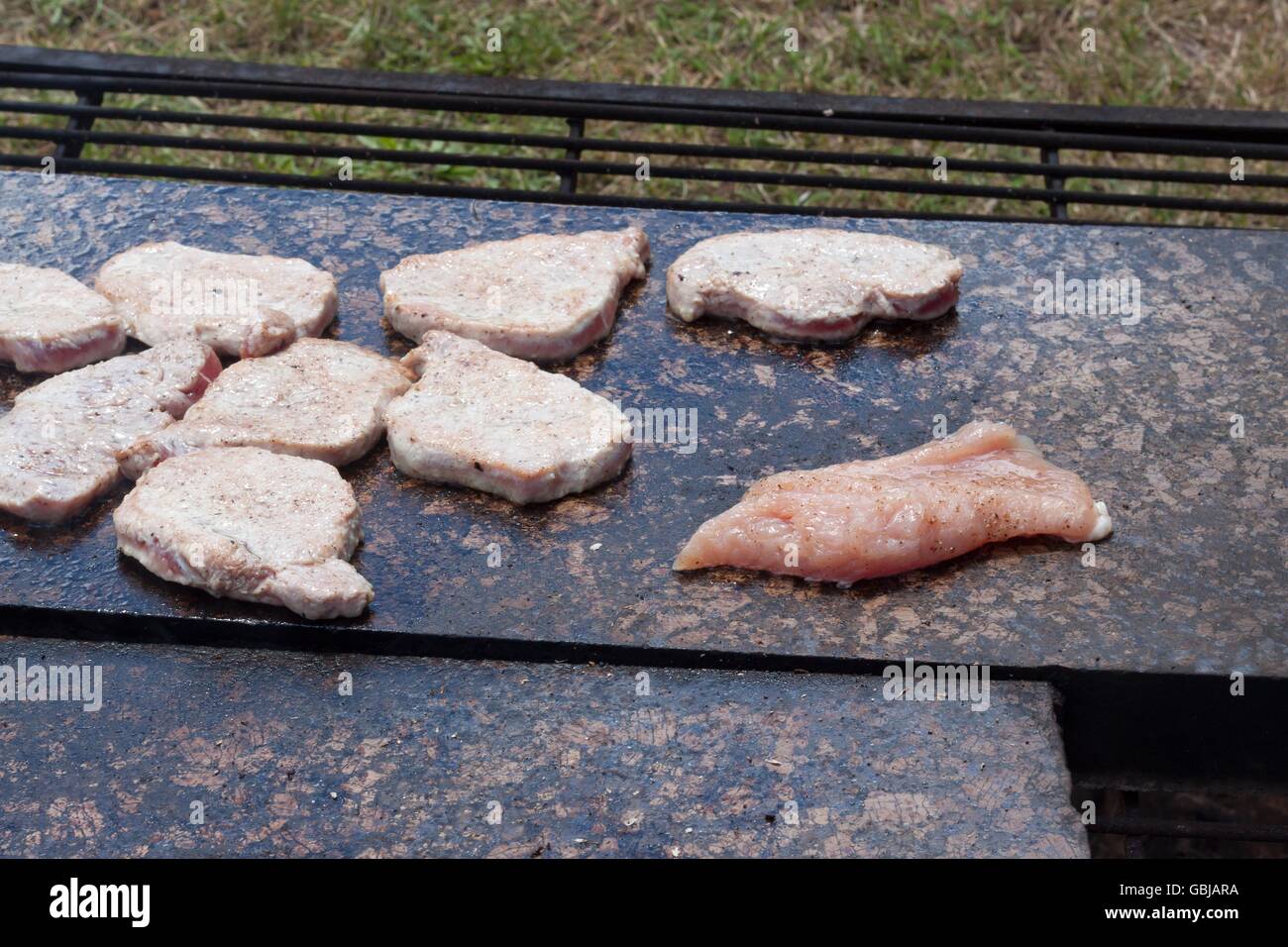 Barbecue pork chops and chicken on a hot granite countertop. Summer ...