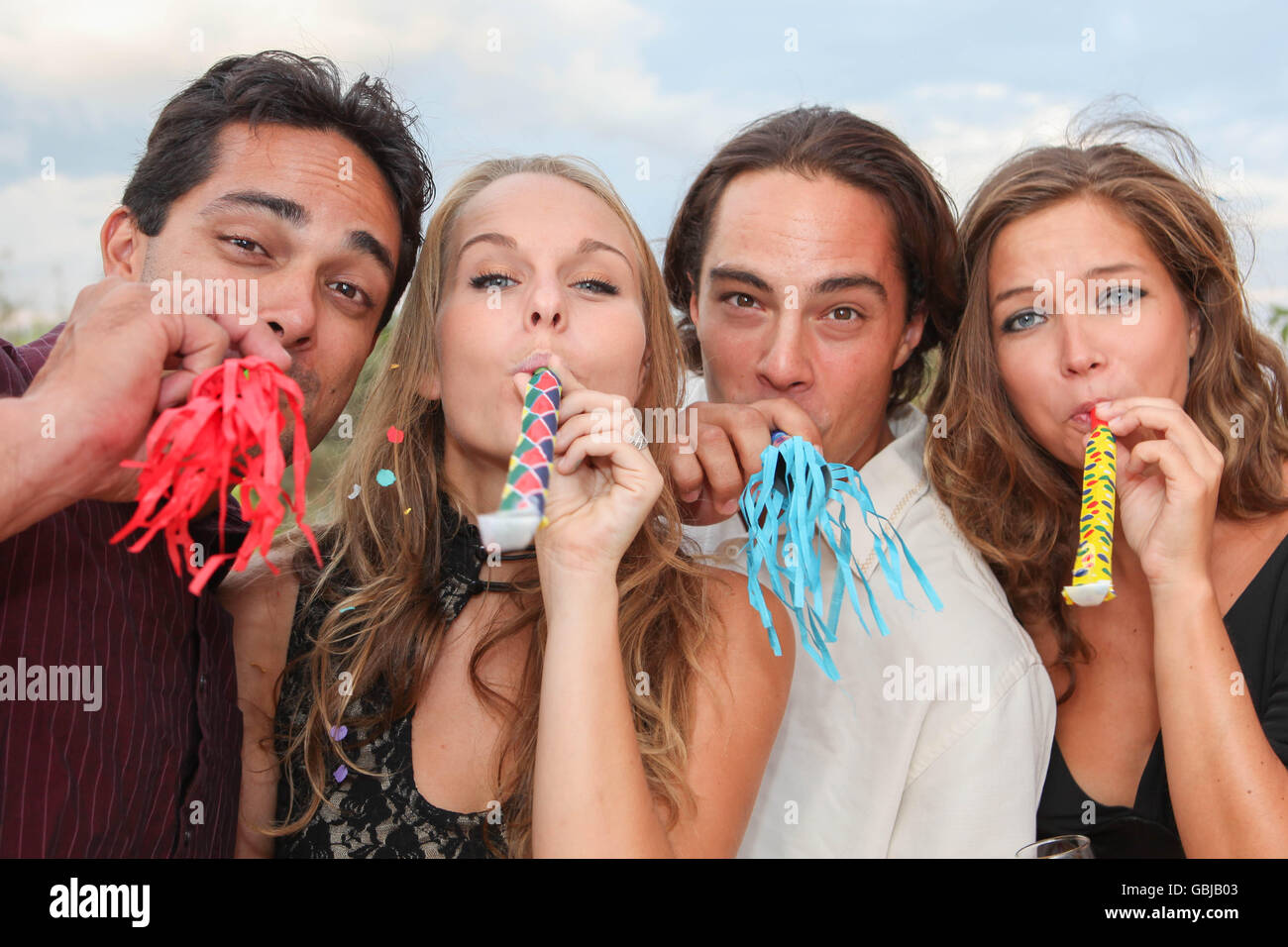 group blowing horns celebrating new year party Stock Photo - Alamy
