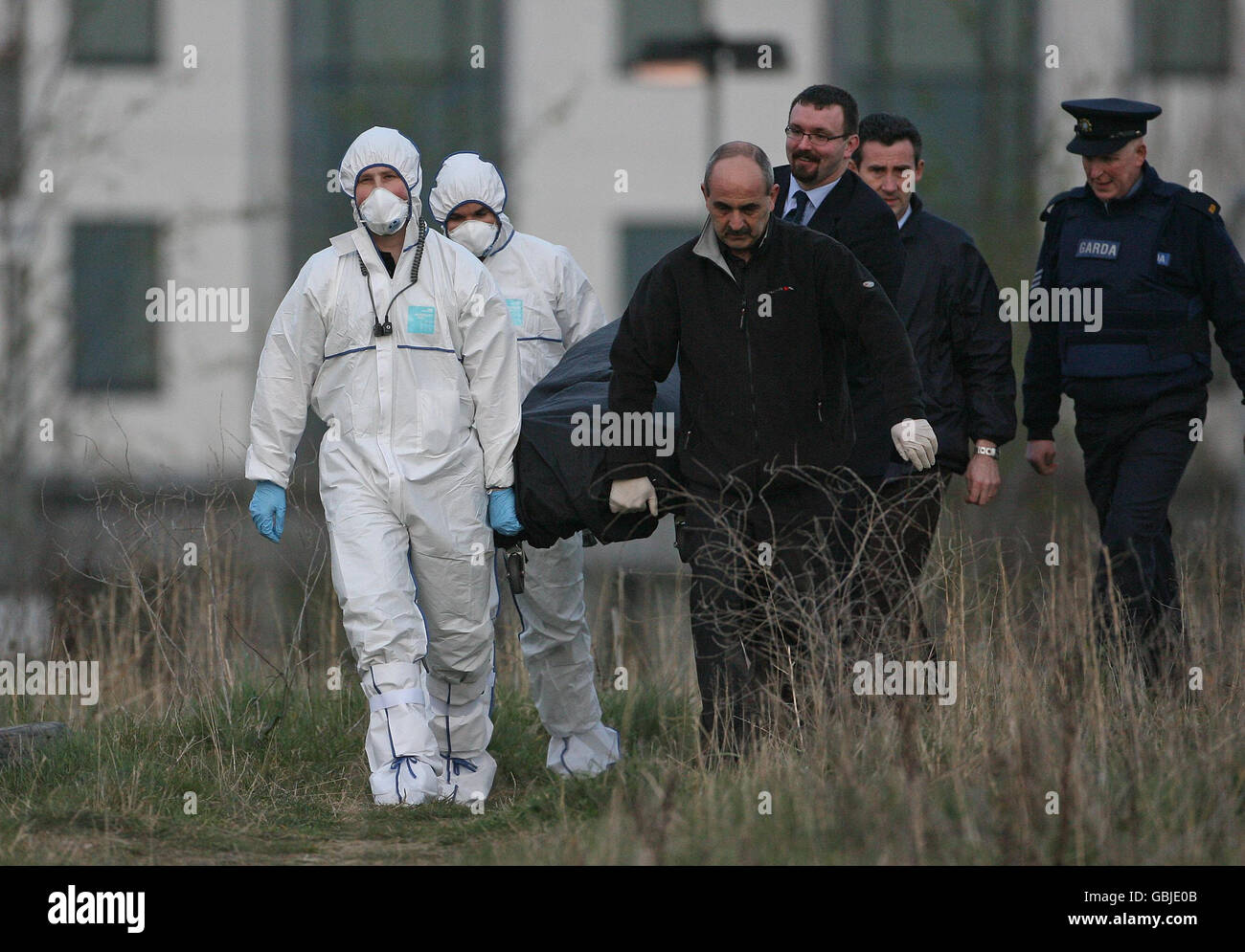Crime scene investigators remove the body of a man believed to be in ...