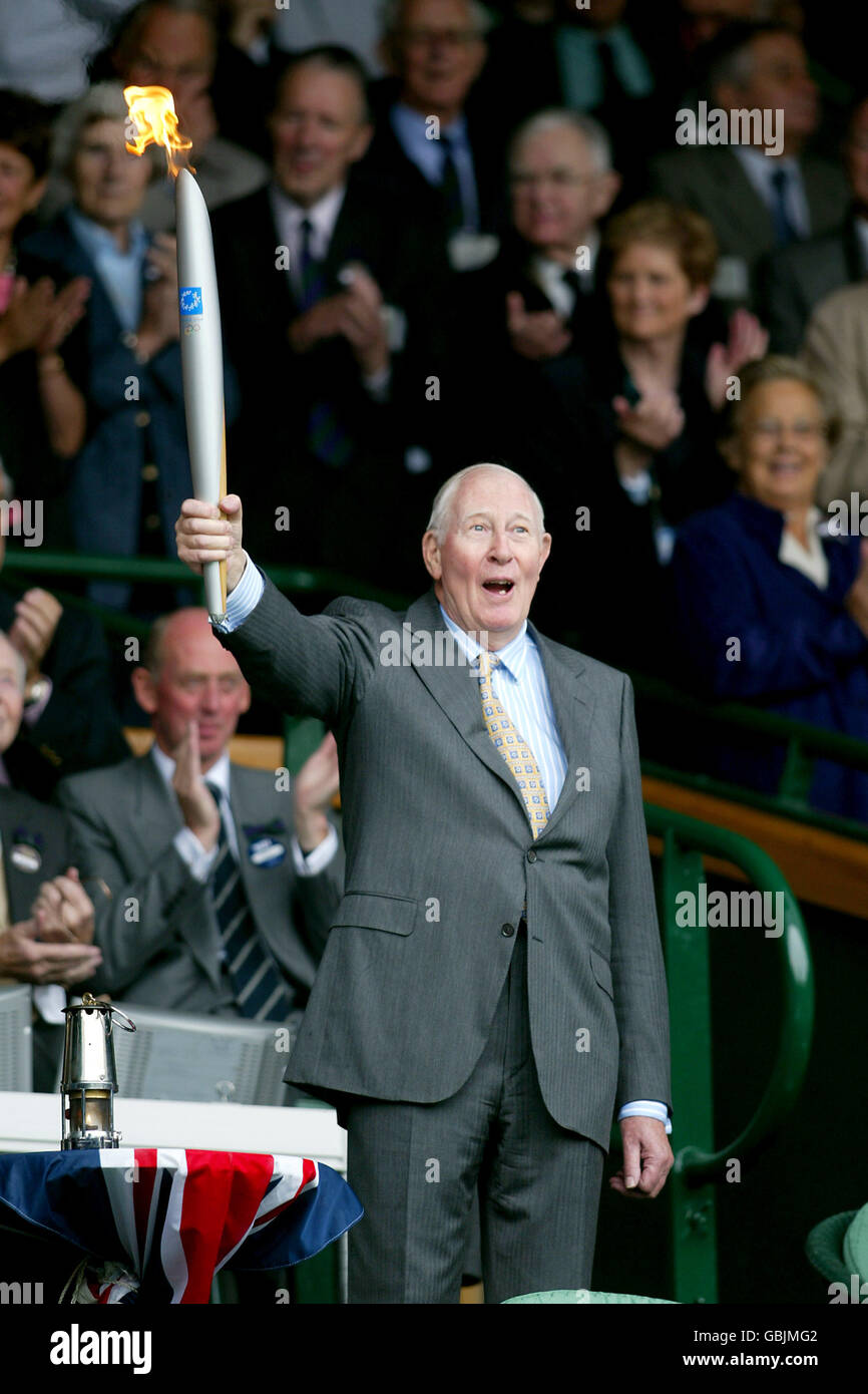 Sir Roger Bannister holds the Olympic Flame as the torch starts its leg ...