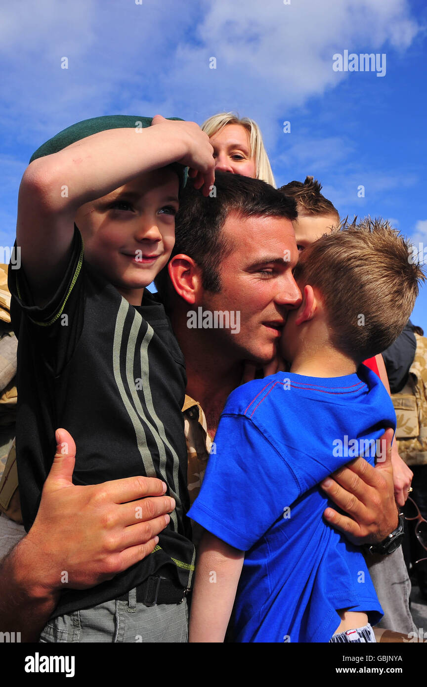 Sergent Ed Needham from Lympstone gives his son Tyler, five, a kiss and ...