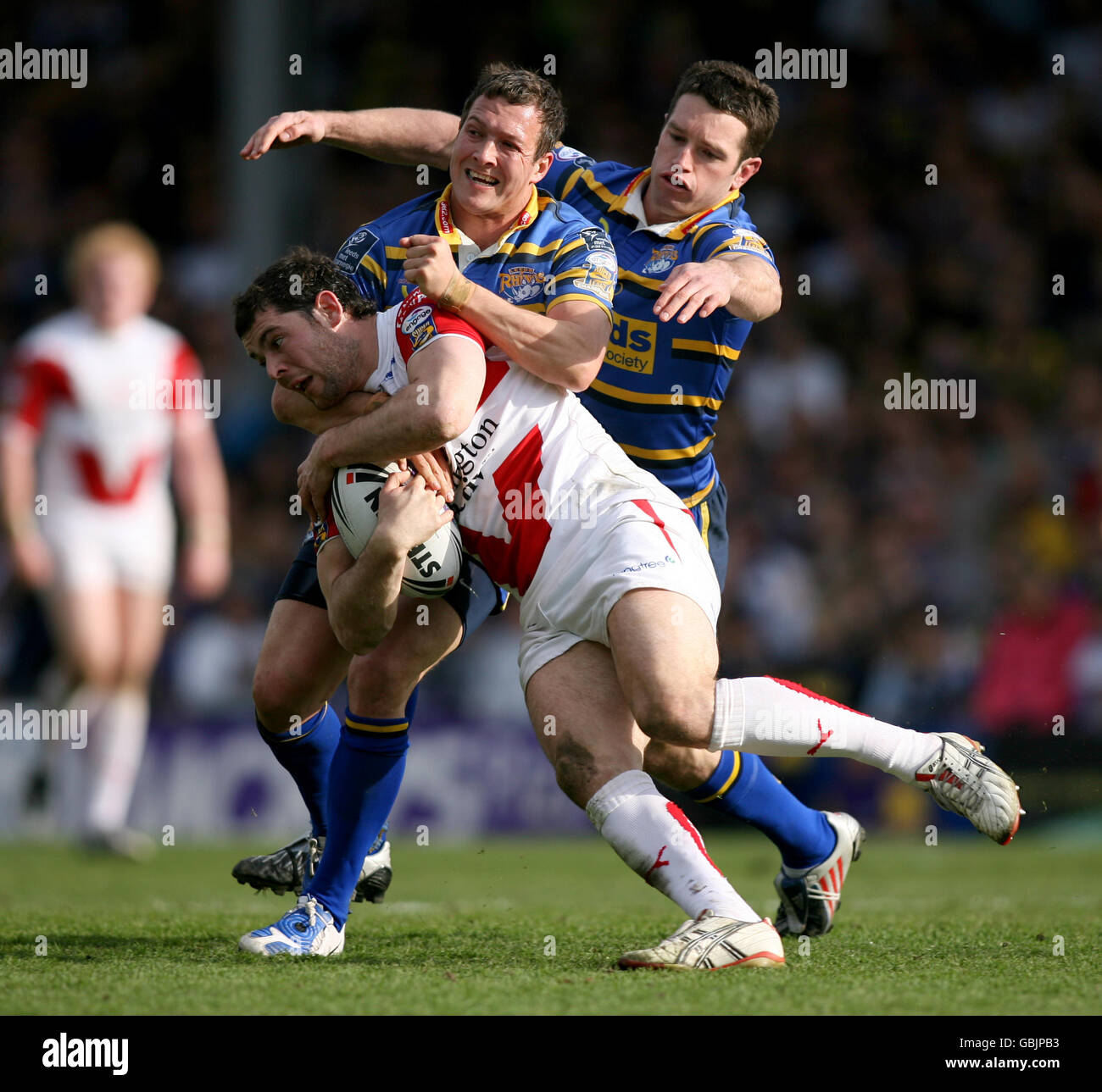 Leeds Rhinos' Danny McGuire and Rob Burrow tackle St. Helens' Paul ...