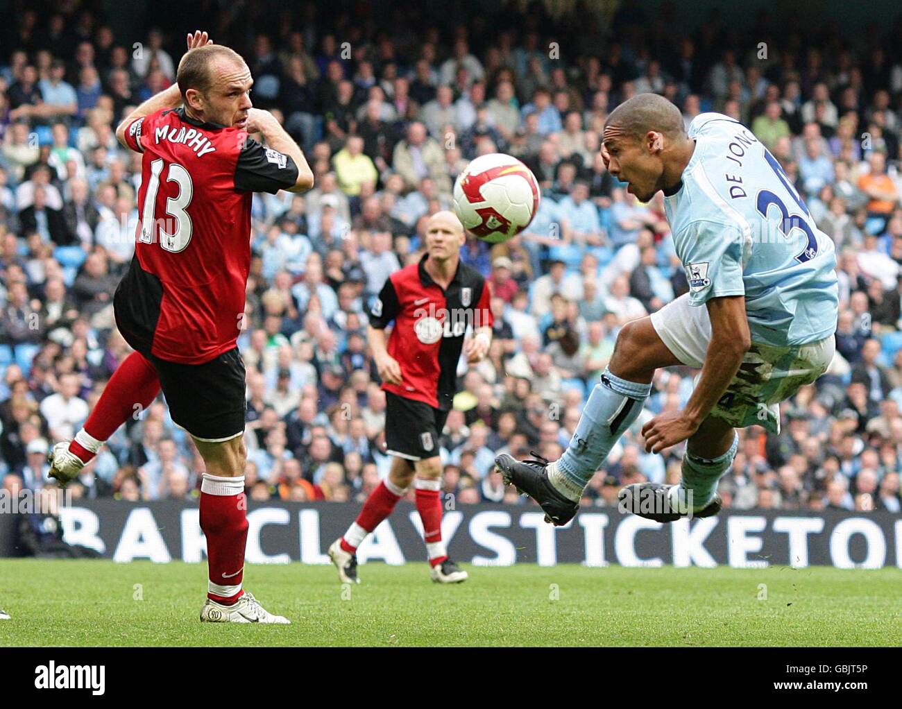 Manchester City's Nigel De Jong (right) has a shot on goal Stock Photo ...
