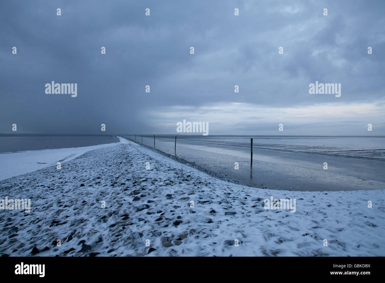 Snow-covered coastline, navigable channel at dusk, North Sea resort of ...