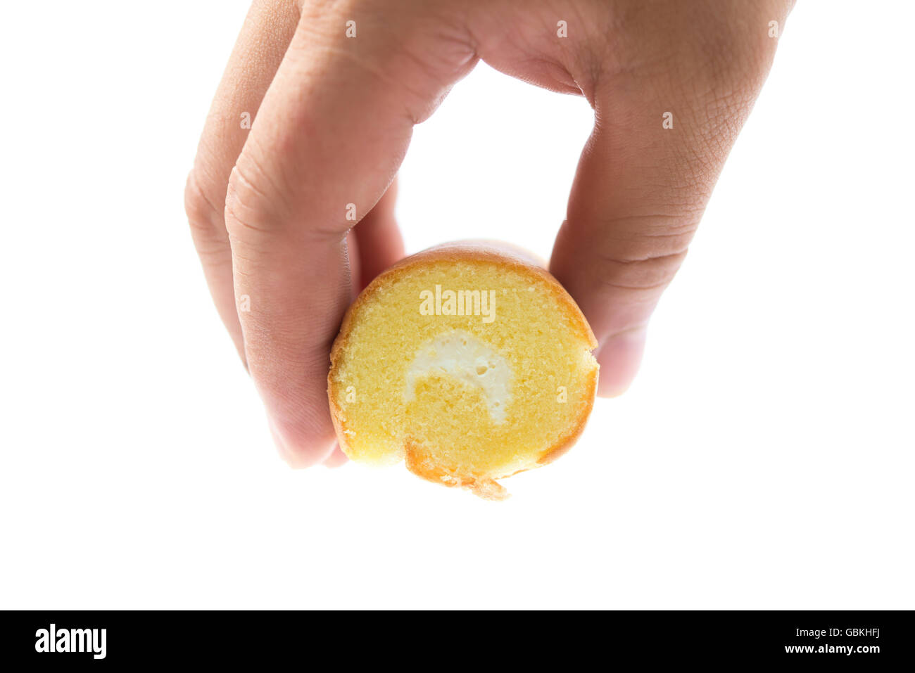 hand holding a piece of cake with cream in middle on white Stock Photo ...