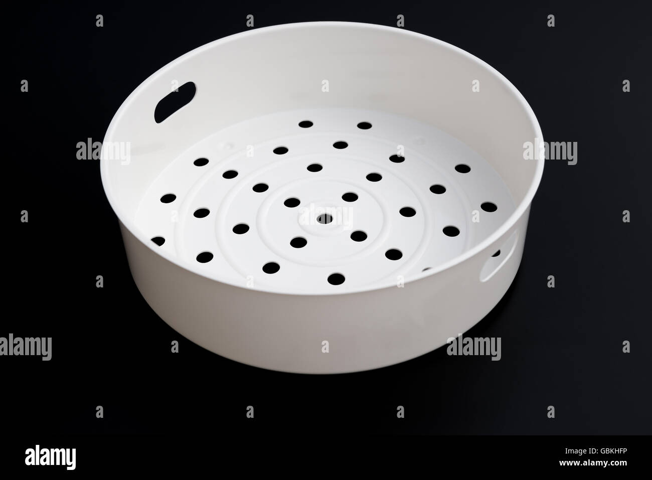 white plastic steamer on black background Stock Photo - Alamy