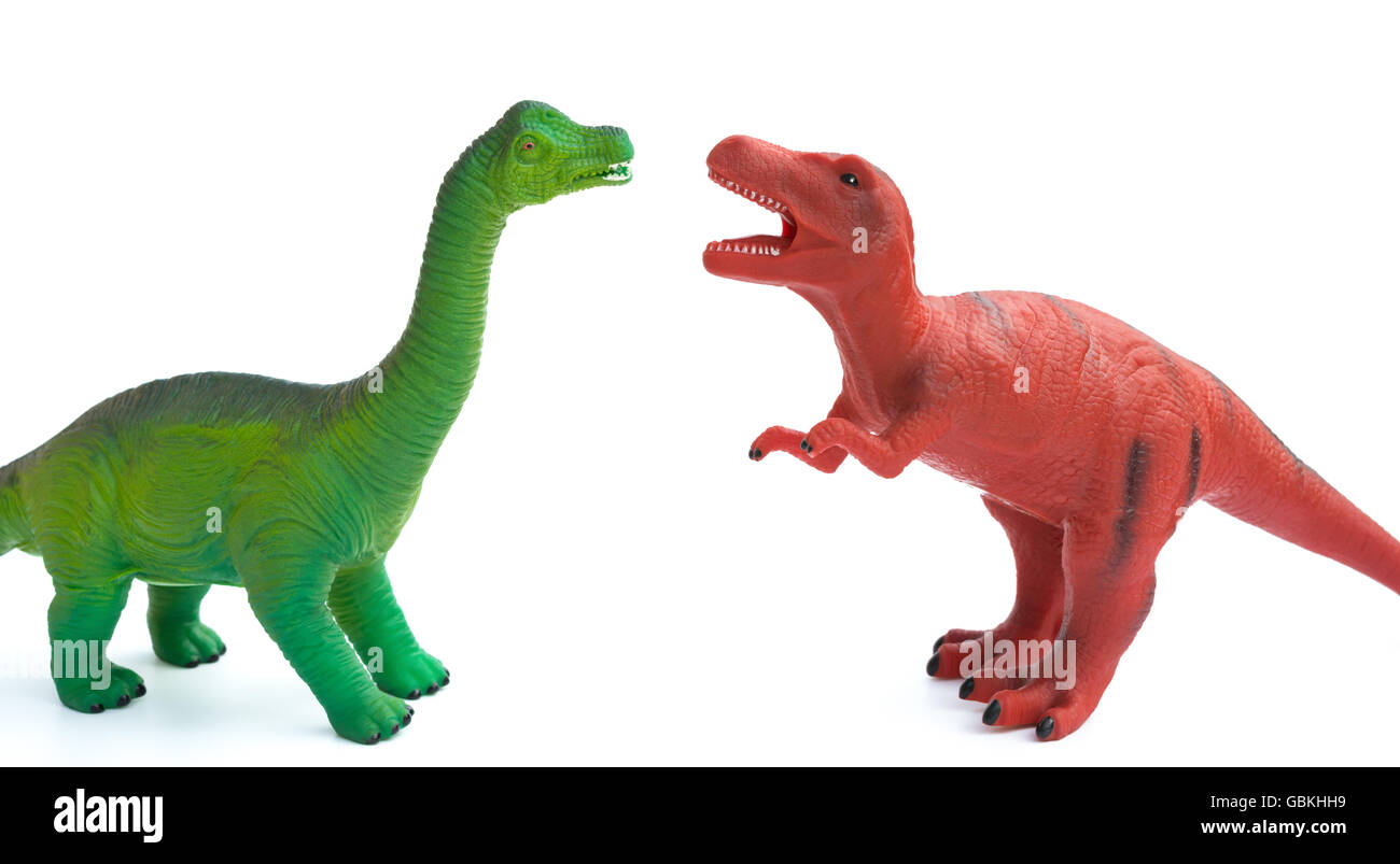 green brachiosaurus and red tyrannosaurus toys on a white background ...