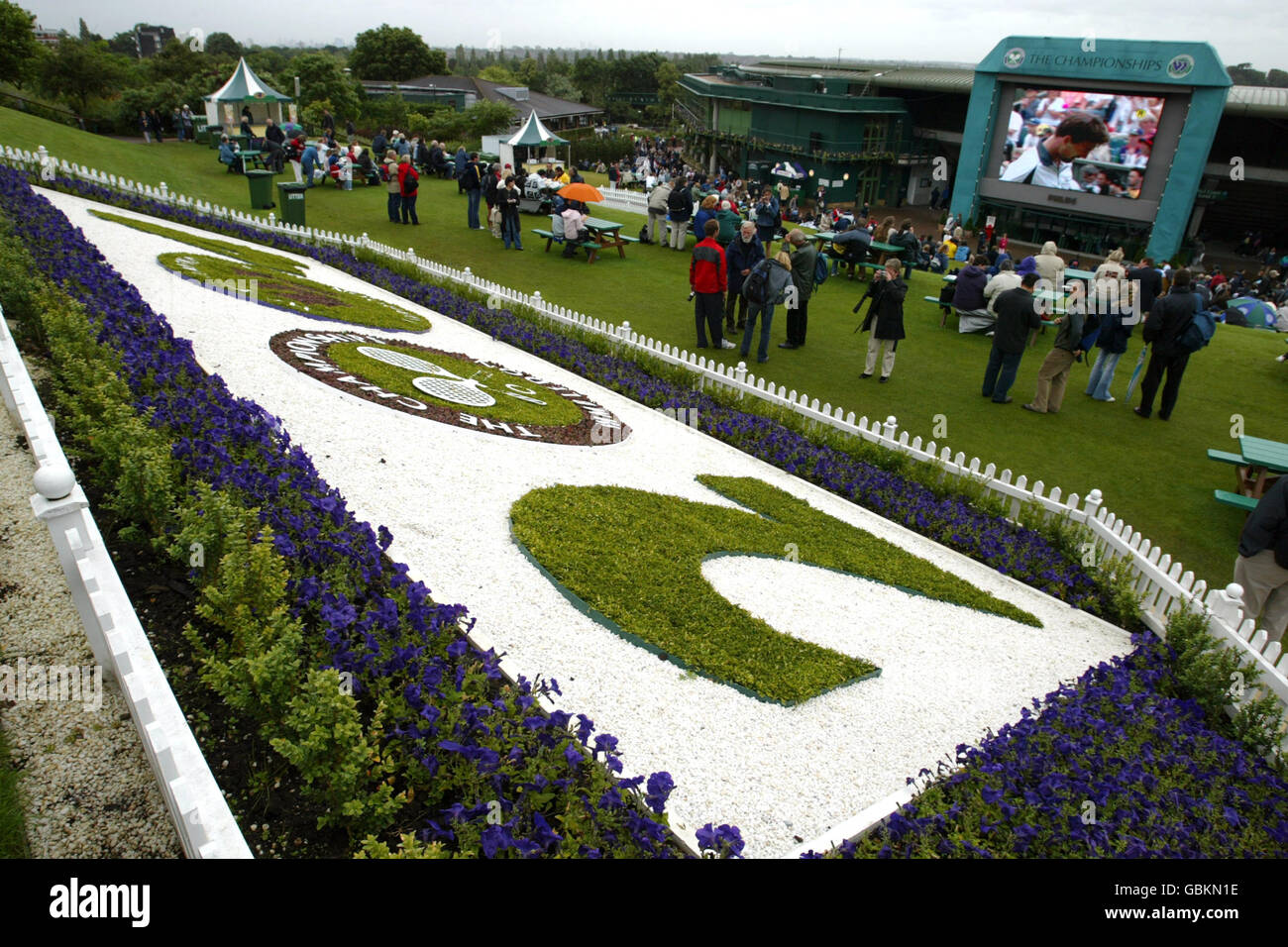 Spectators on Henman Hill watch the big screen during the bad weather ...