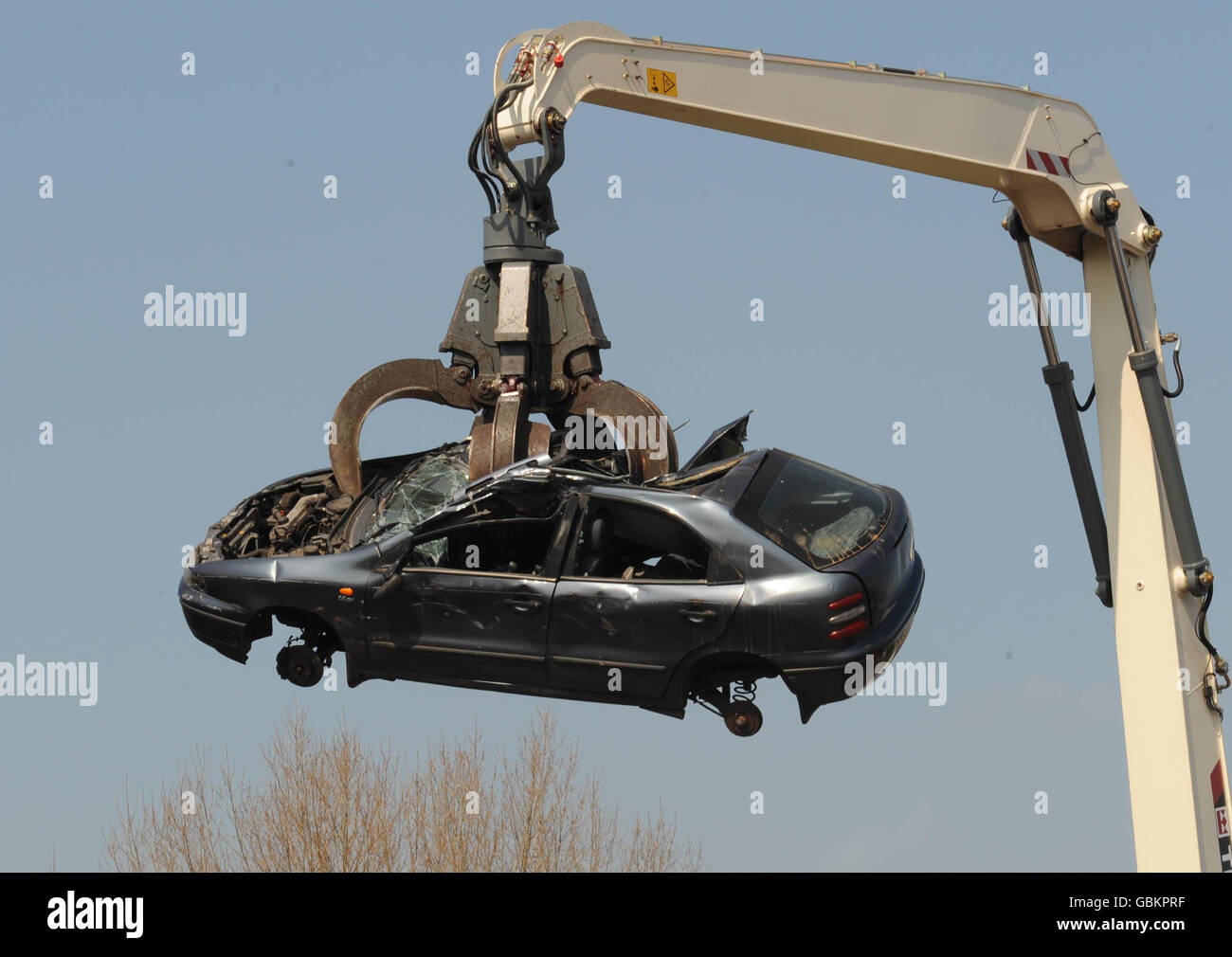 A scrapped car is lifted towards the crusher at Phelps Bros Ltd iron ...