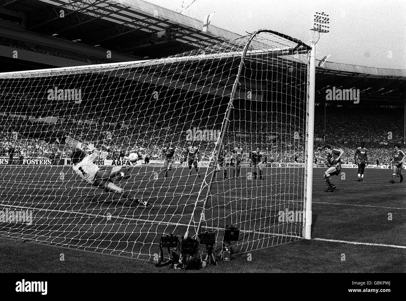 Wimbledon goalkeeper Dave Beasant (l) dives to save a penalty from ...