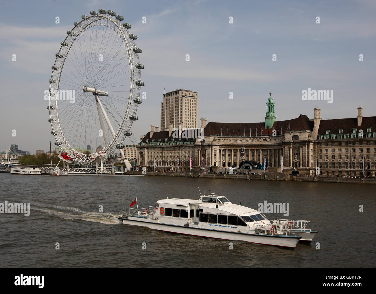A sightseeing boat, operated by Thames Clippers, sails past the London ...