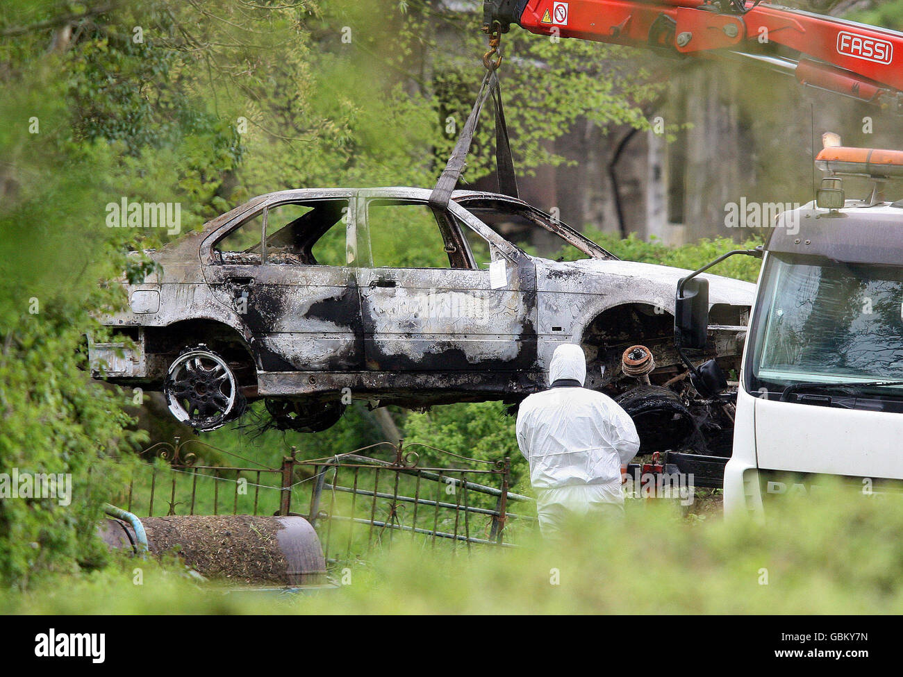 Police forensic experts, recover a burnt out BMW car from an isolated ...