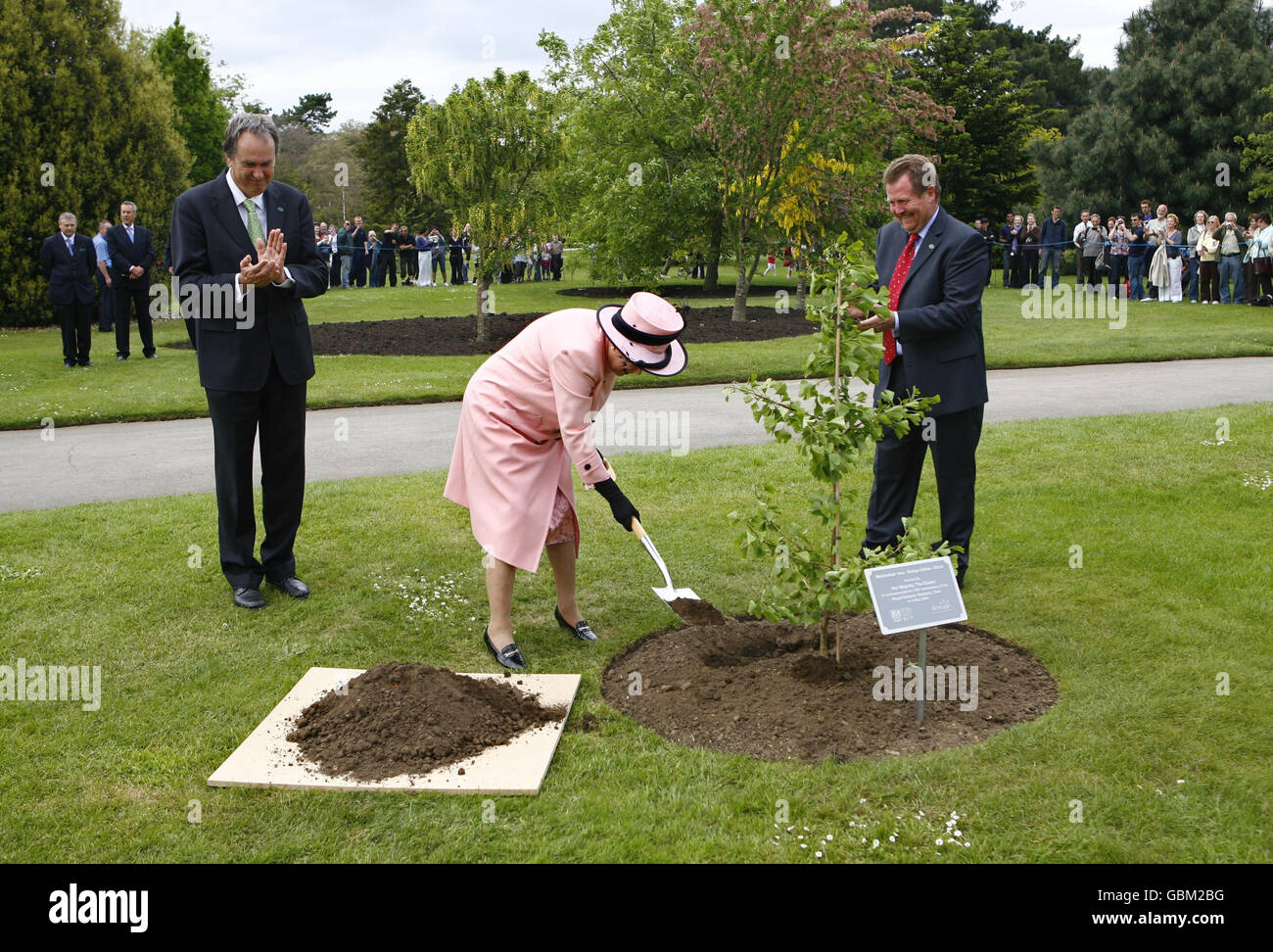 Queen Elizabeth II plants a tree during a visit to The Royal Botanic ...