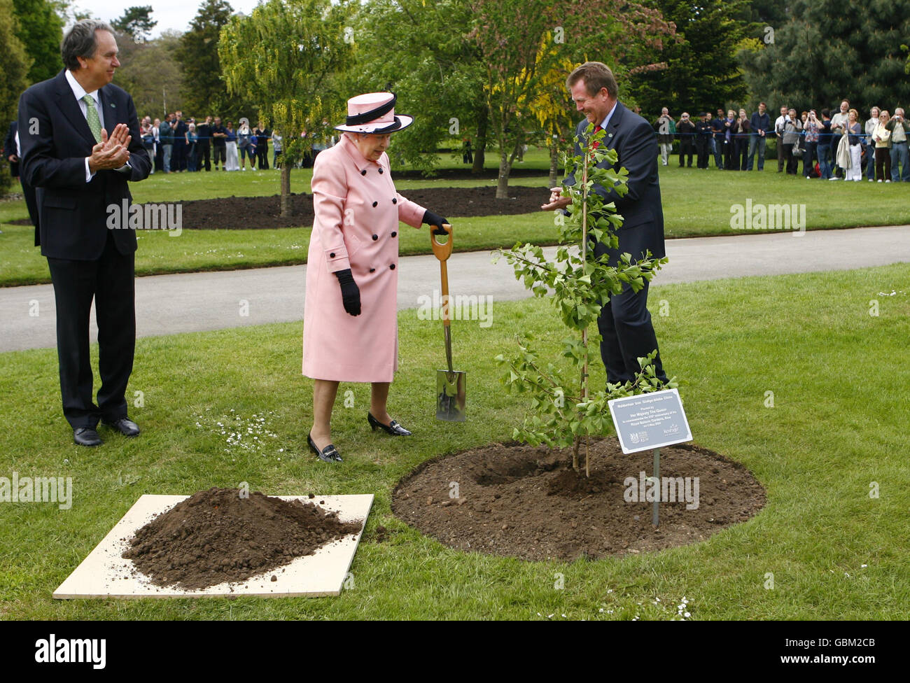 Queen Elizabeth II plants a tree during a visit to The Royal Botanic ...