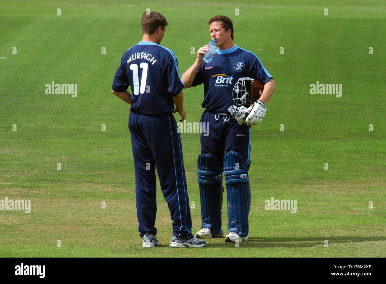 Surrey's Tim Murtagh (l) brings Jonathan Batty a drink during a break ...