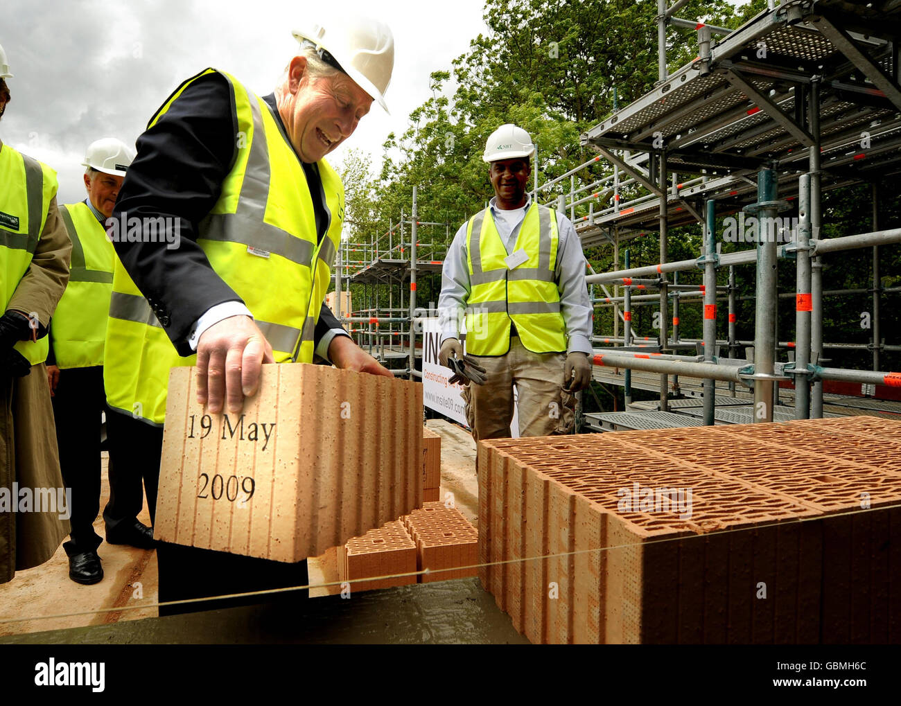 The Prince of Wales lays a thermoplan block with site manger Wilf ...