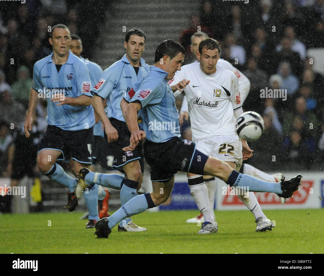 Scunthorpe's Cliff Byrne in action with MK Dons' Peter Leven during the ...
