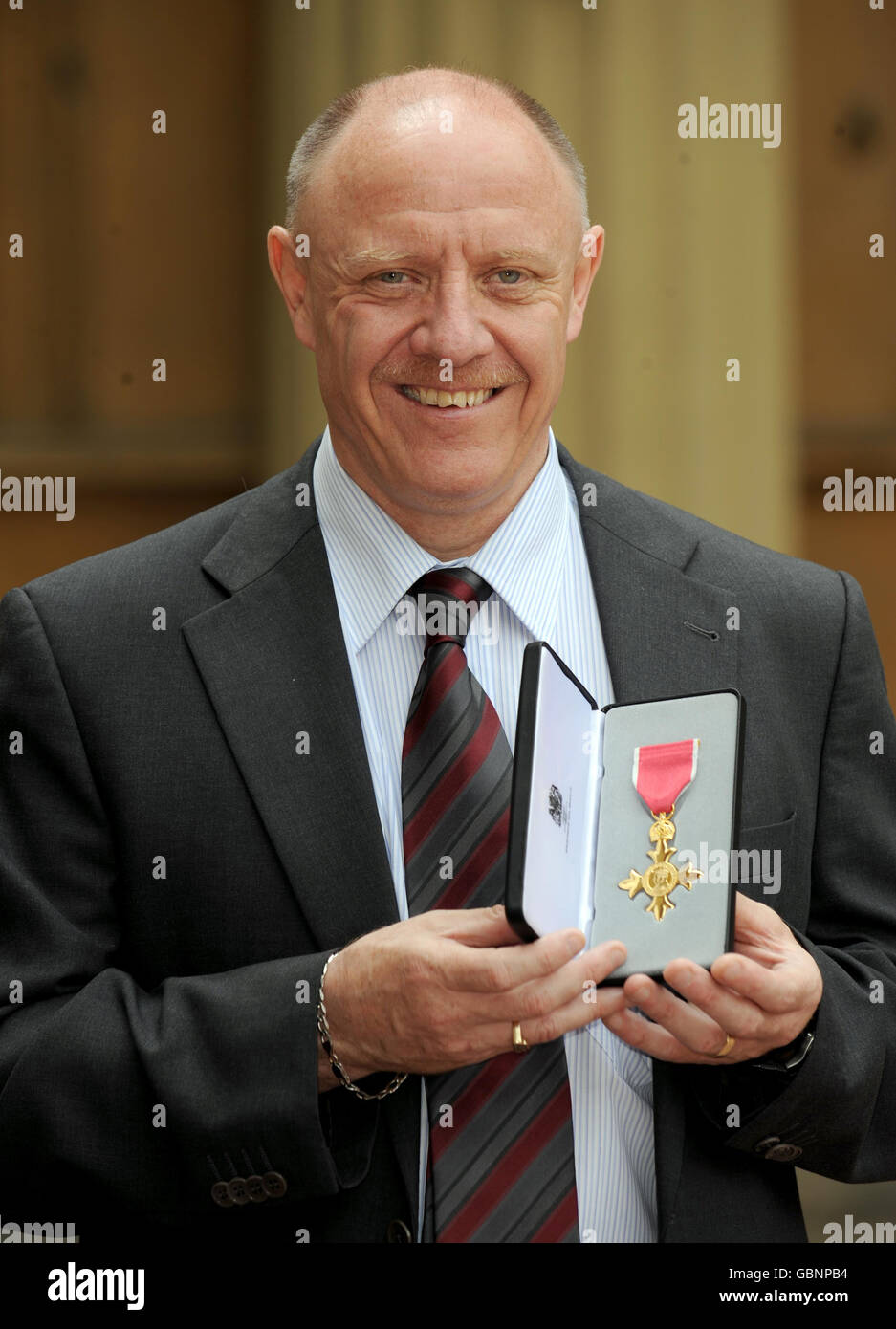 Timothy reddish poses outside buckingham palace with his obe hi-res ...