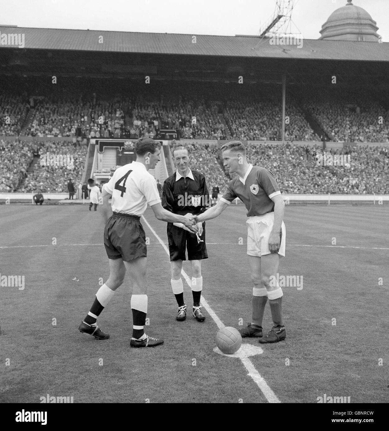 Referee jack kelly looks on as the two captains Black and White Stock ...