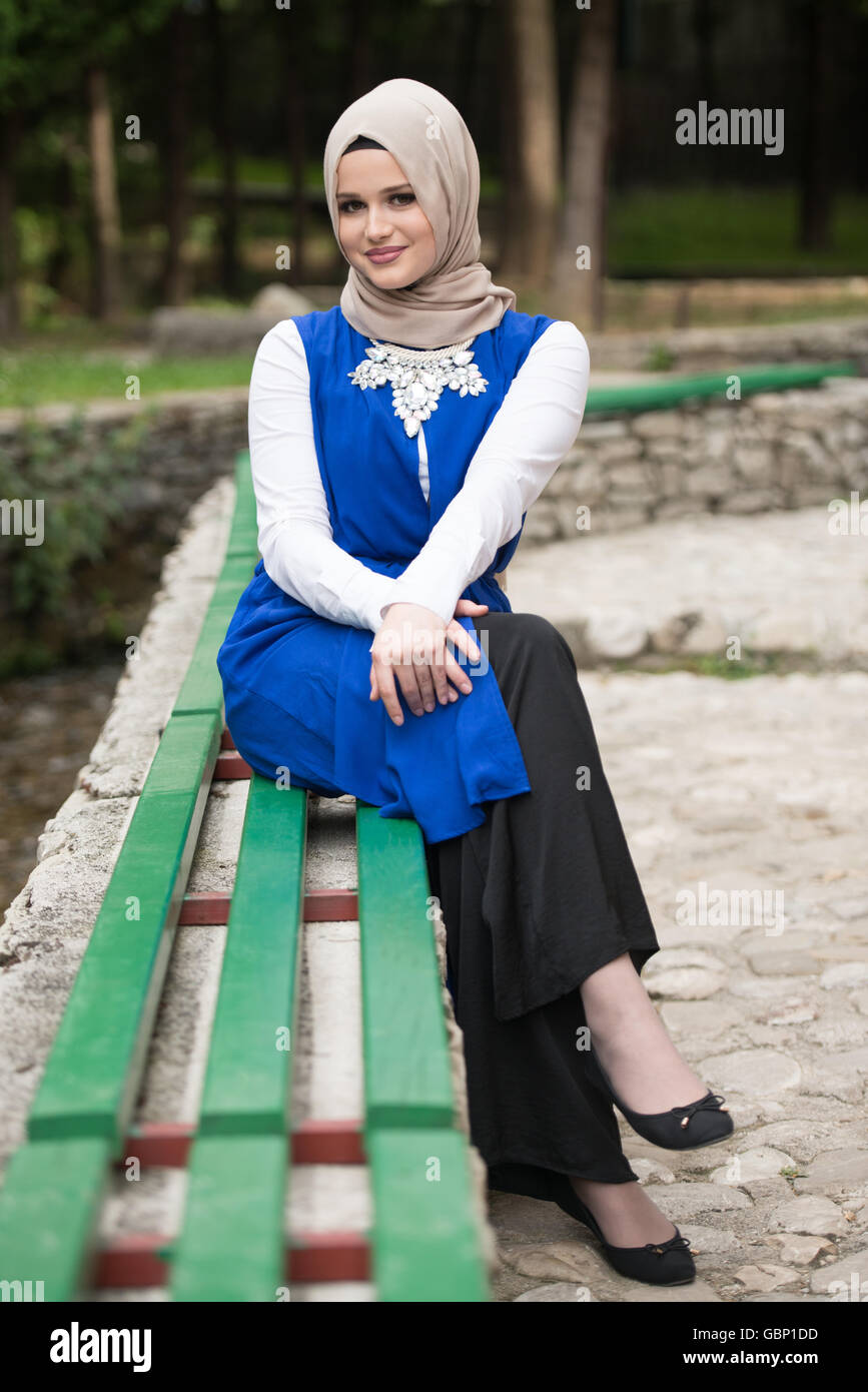 Portrait Of Young Muslim Woman Sitting On Bench In Park Stock Photo - Alamy