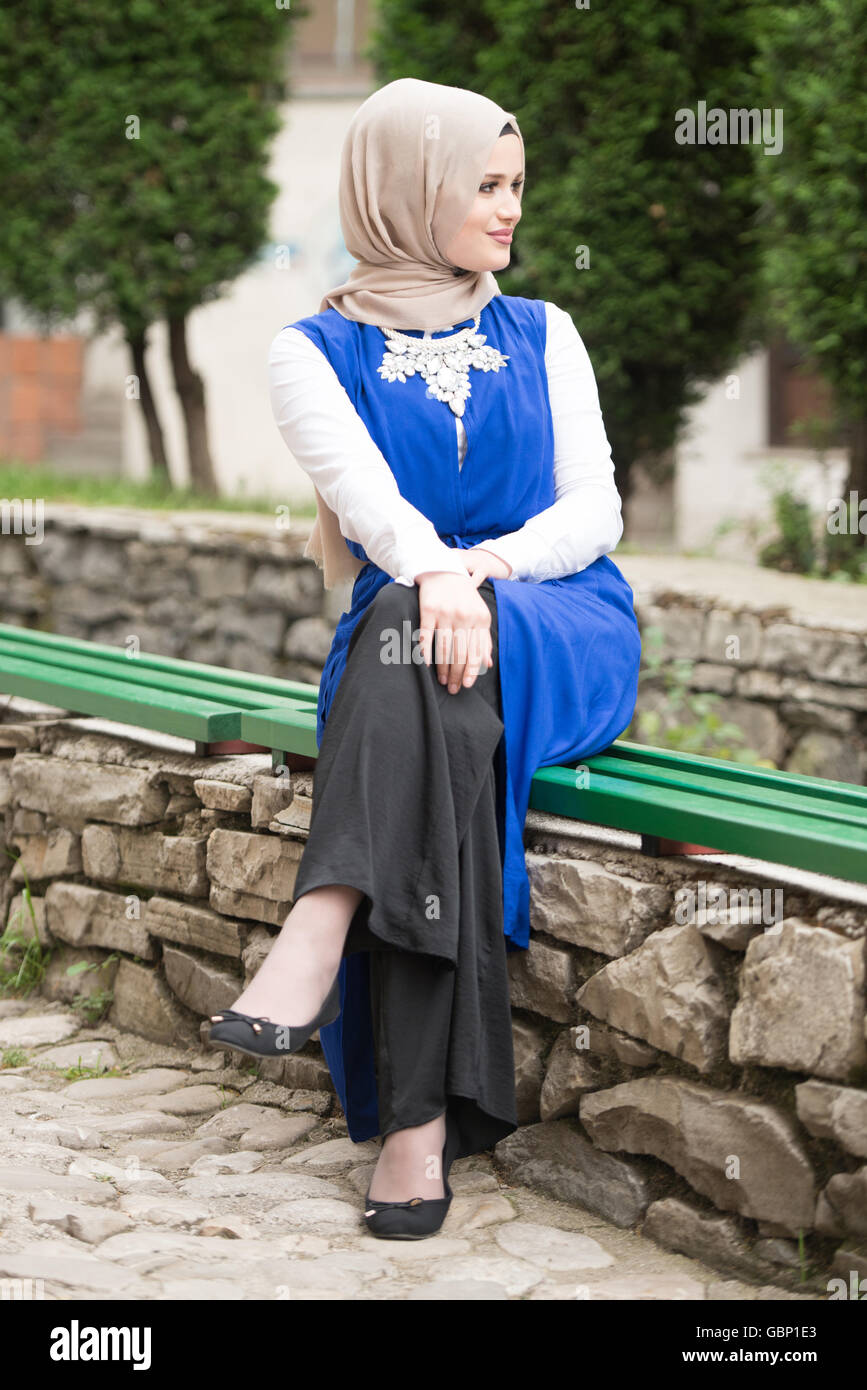 Portrait Of Young Muslim Woman Sitting On Bench In Park Stock Photo - Alamy