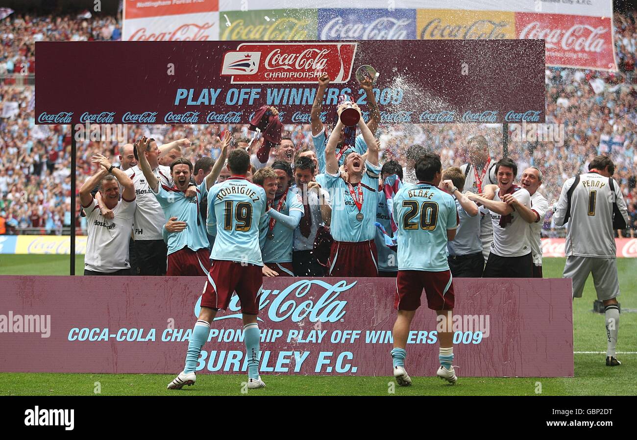 Burnley players celebrate with the trophy after gaining promotion into ...