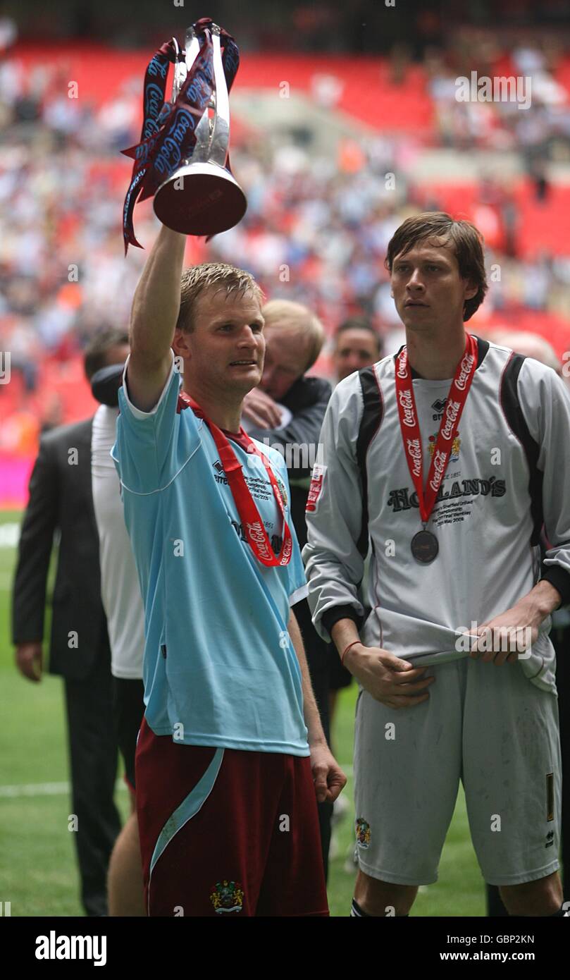 Burnley's Christian Kalvenes (left) celebrates with the trophy as their ...
