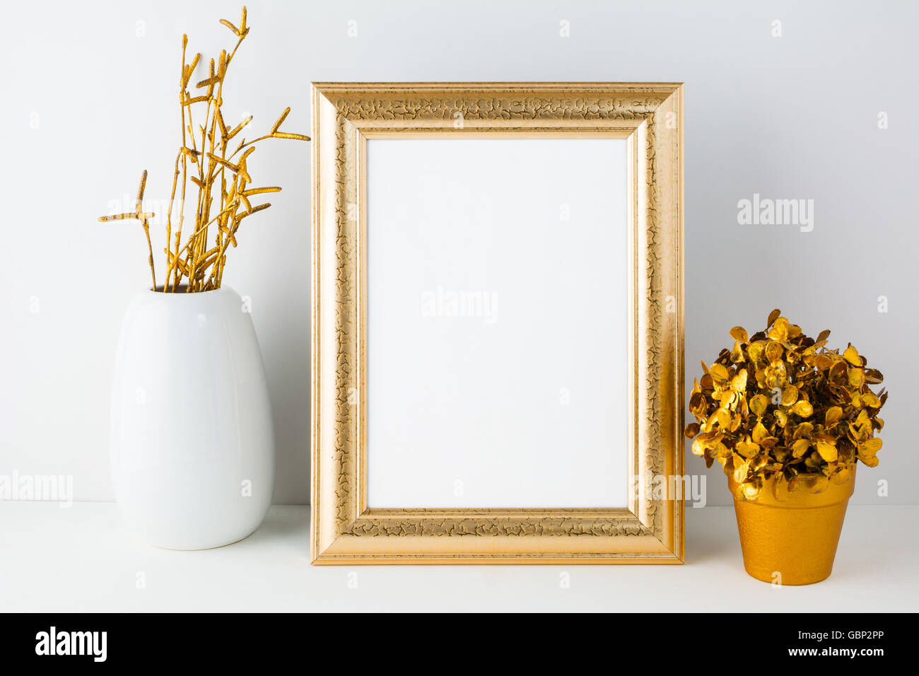 Gold fame mockup with white vase and golden flowerpot. Empty gold frame ...