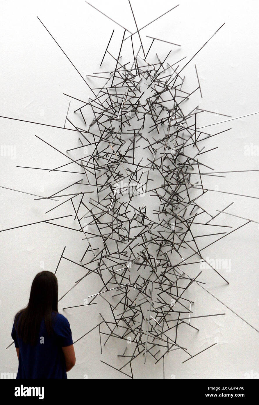 A woman looks at Quantum Void VI, a sculpture by Antony Gormley showing ...