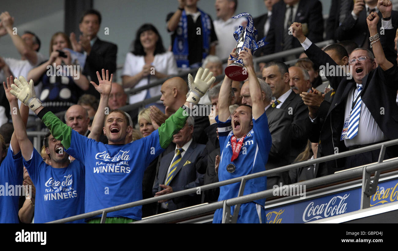Gillingham's captain Barry Fuller (right) lifts the trophy during the ...