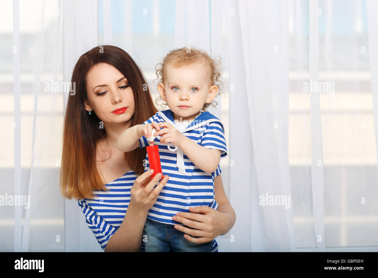 Young mother and little daughter inflate soap bubbles. Mother and ...
