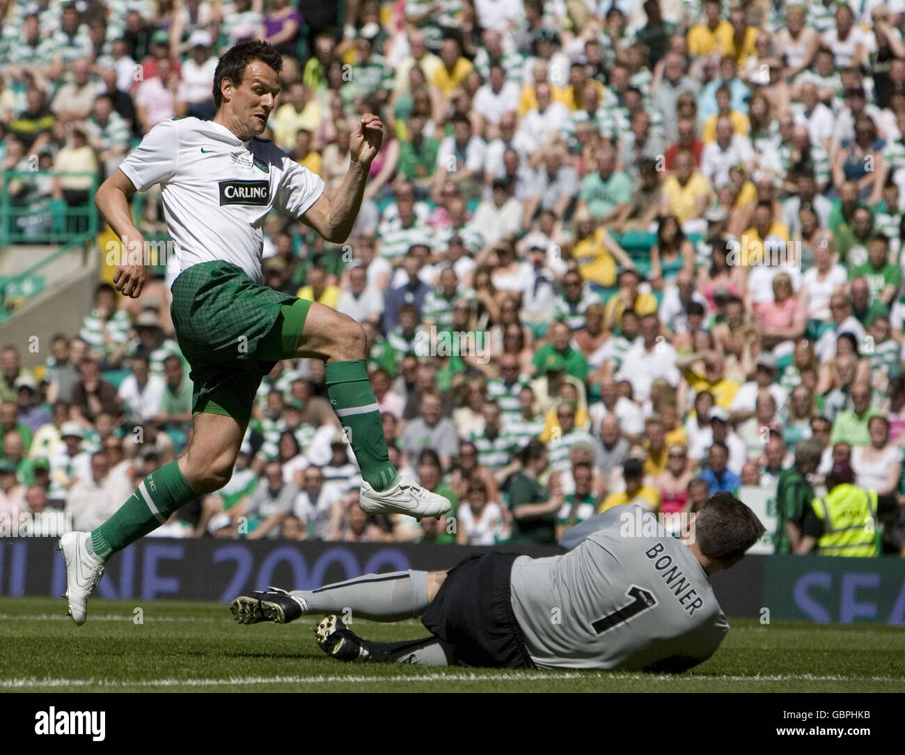 Celtic's Jan Vennegoor of Hesselink leaps over Tommy Burns Select's ...