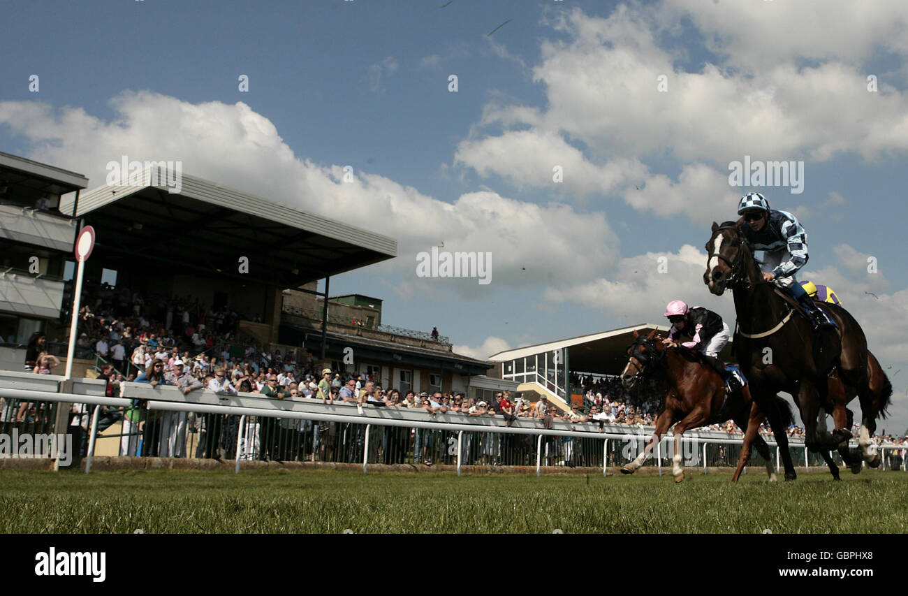 A general view of runners and riders as they pass the finish post in ...