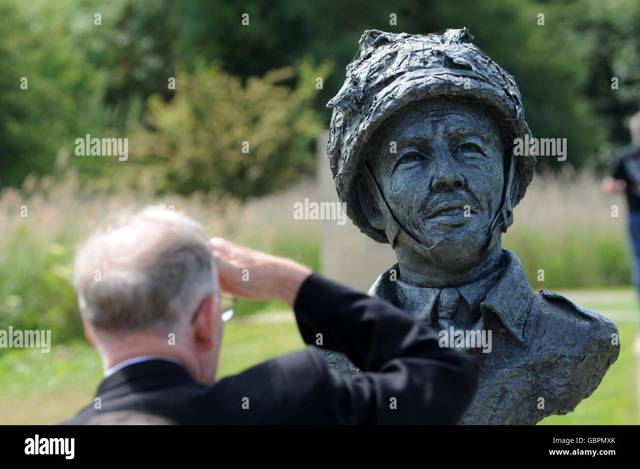 A veteran stands at the bust of Major Howard, who led the raid on ...