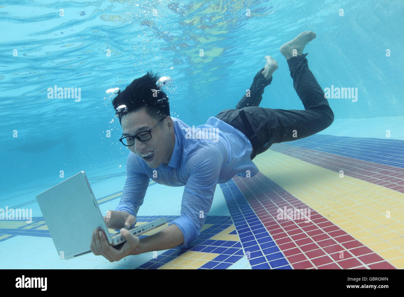 Young men use computers under water Stock Photo - Alamy