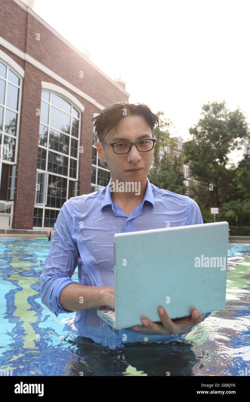 Using computer in swimming pool hi-res stock photography and images - Alamy